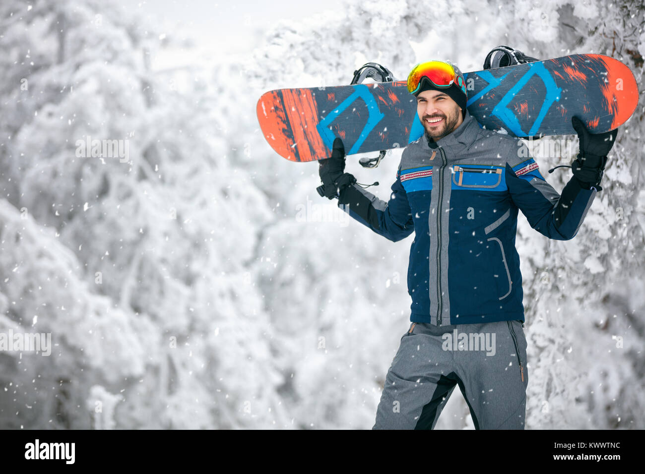 Male snowboarder with board going to ski terrain Stock Photo - Alamy