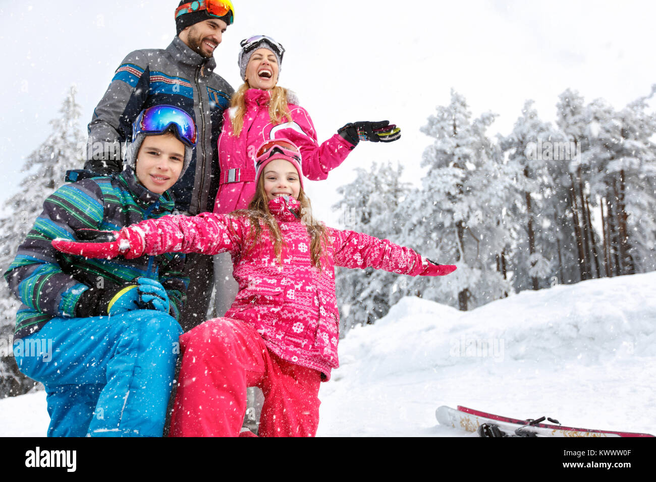 Happy family with children enjoying on winter vacation in snowy nature ...