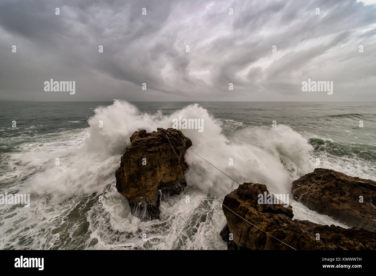 crashing waves with a moody sky at Farol Da Nazare Portugal Stock Photo ...