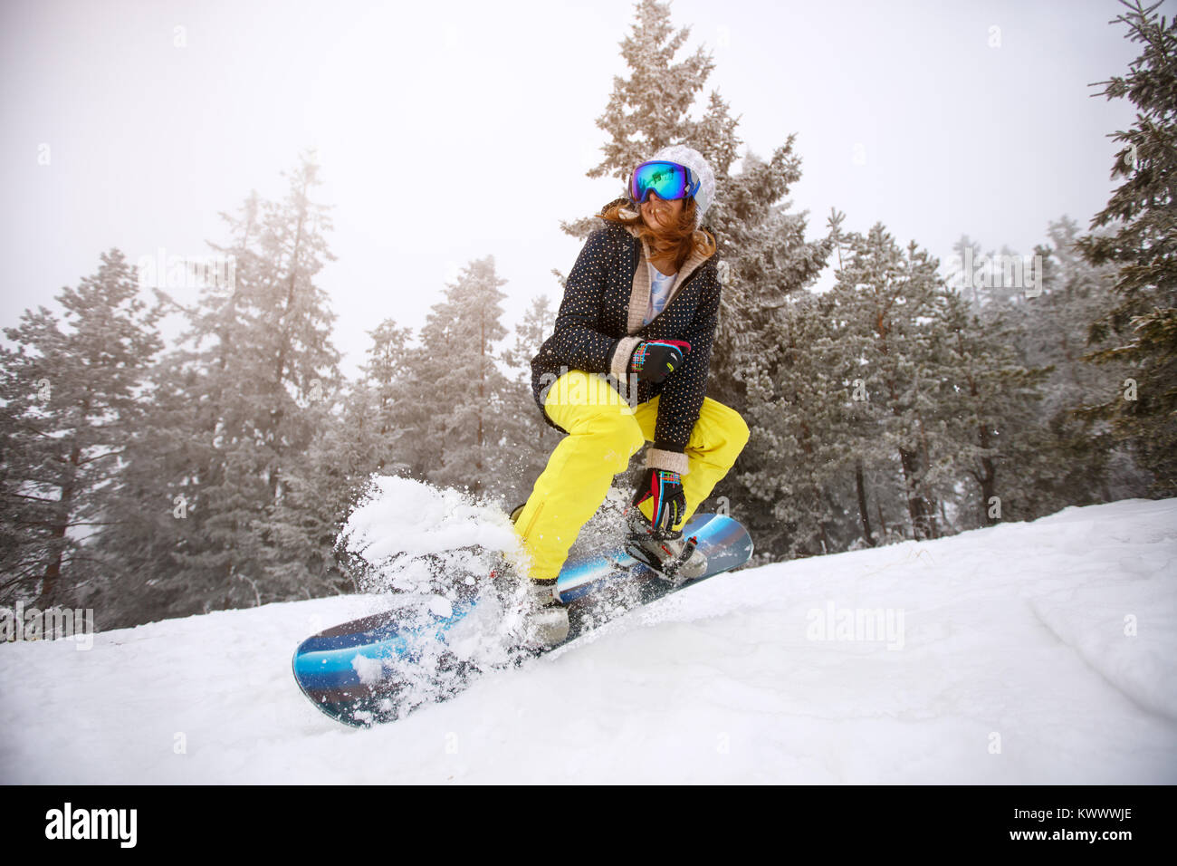 Trained snowboarder girl in action on ski-run Stock Photo - Alamy