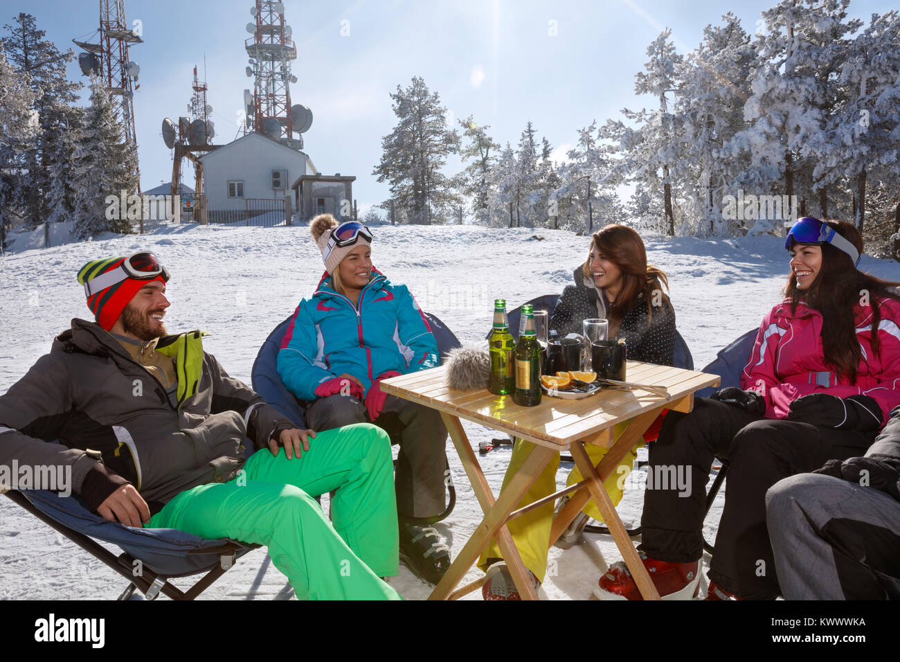 Skiers drinking beverage and resting from skiing in cafe on ski terrain ...