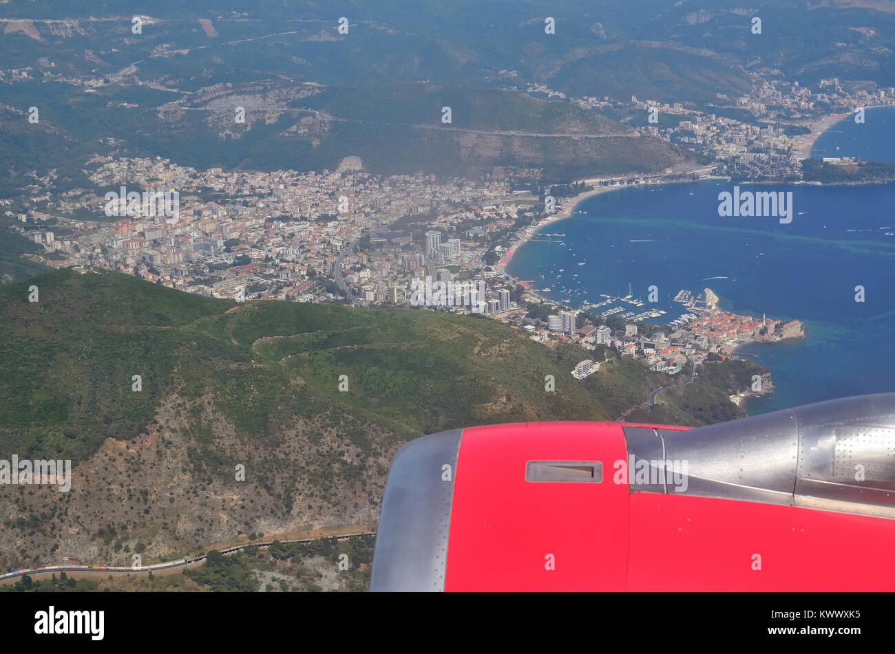 Aerial view from a plane to its red engine, the land, the Adriatic sea ...