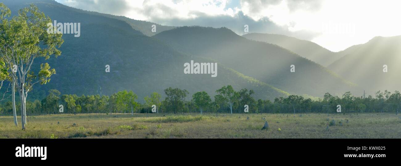 Rays of sunlight penetrate from behind a mountain onto farmland, Mount ...