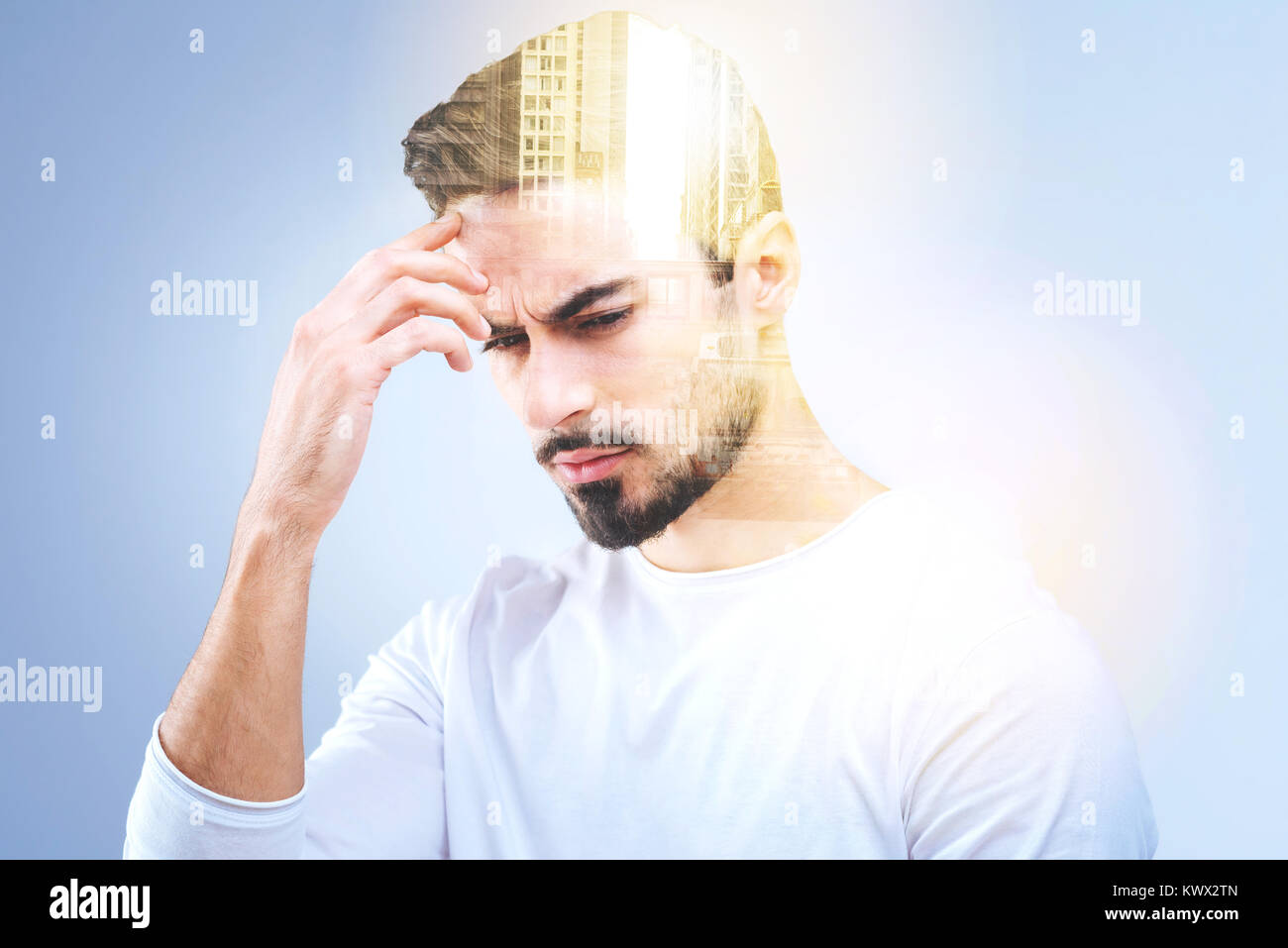 Thoughtful young man holding his forehead Stock Photo - Alamy
