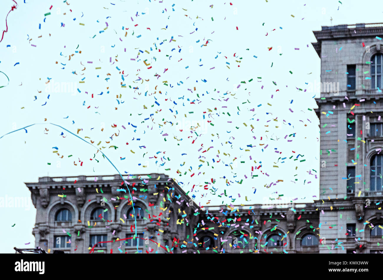 Colored confetti falling, blue sky in a european city, close up ...