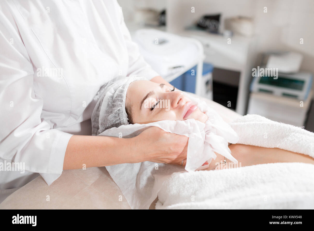 Wipe with sterile napkin face. Young pretty woman receiving treatments ...