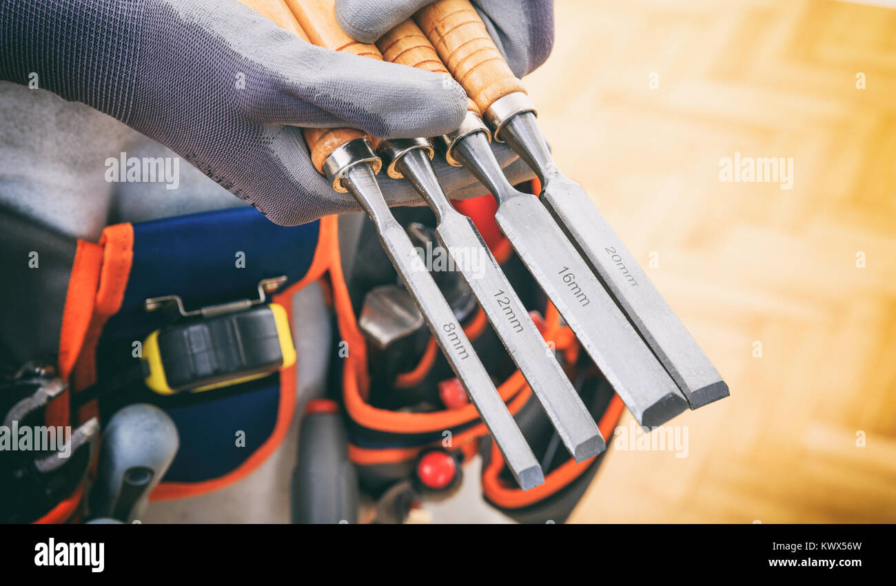 Worker with tool belt holding set of chisels Stock Photo - Alamy