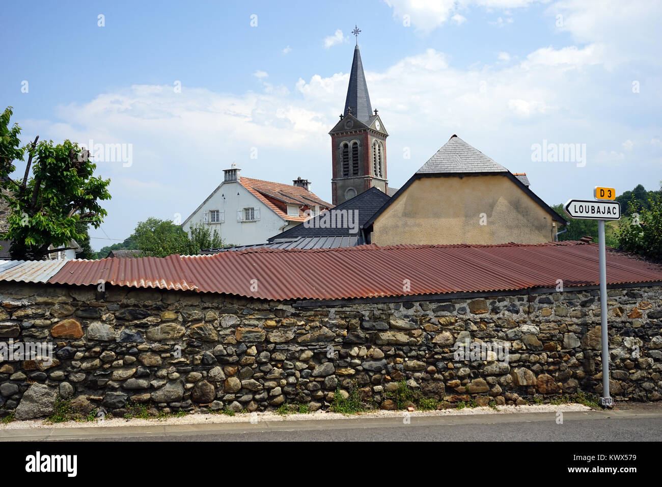 Stone wall and church in Bartres, France Stock Photo - Alamy