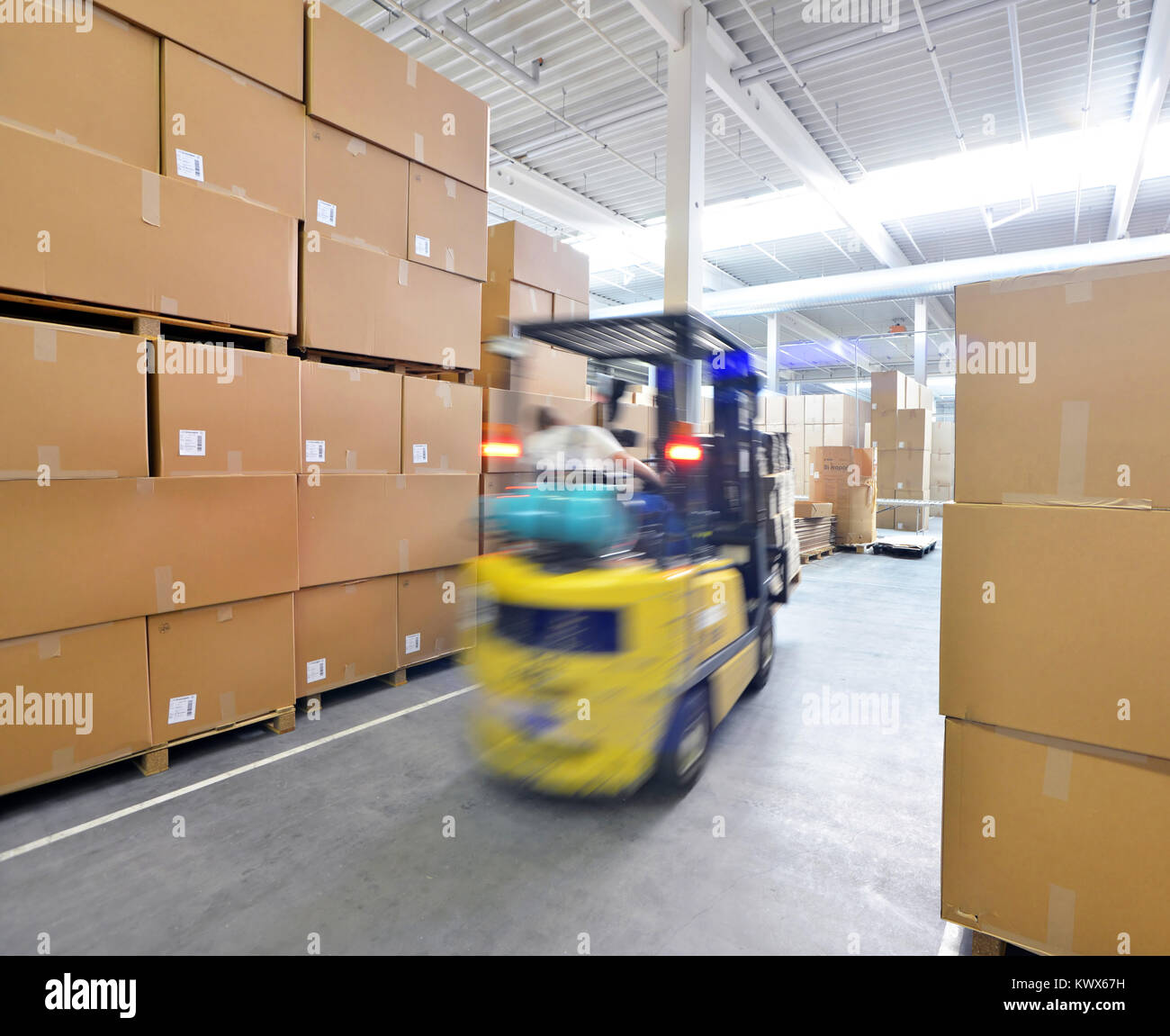forklift driver in a warehouse for industrial goods Stock Photo - Alamy