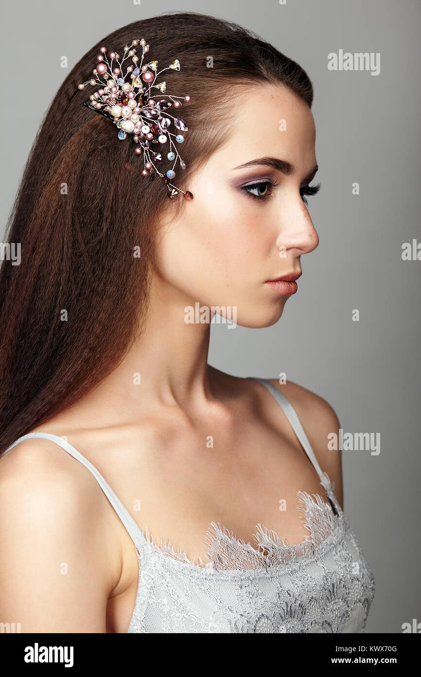 Beauty portrait of young woman. Brunette girl with brooch in long hair ...
