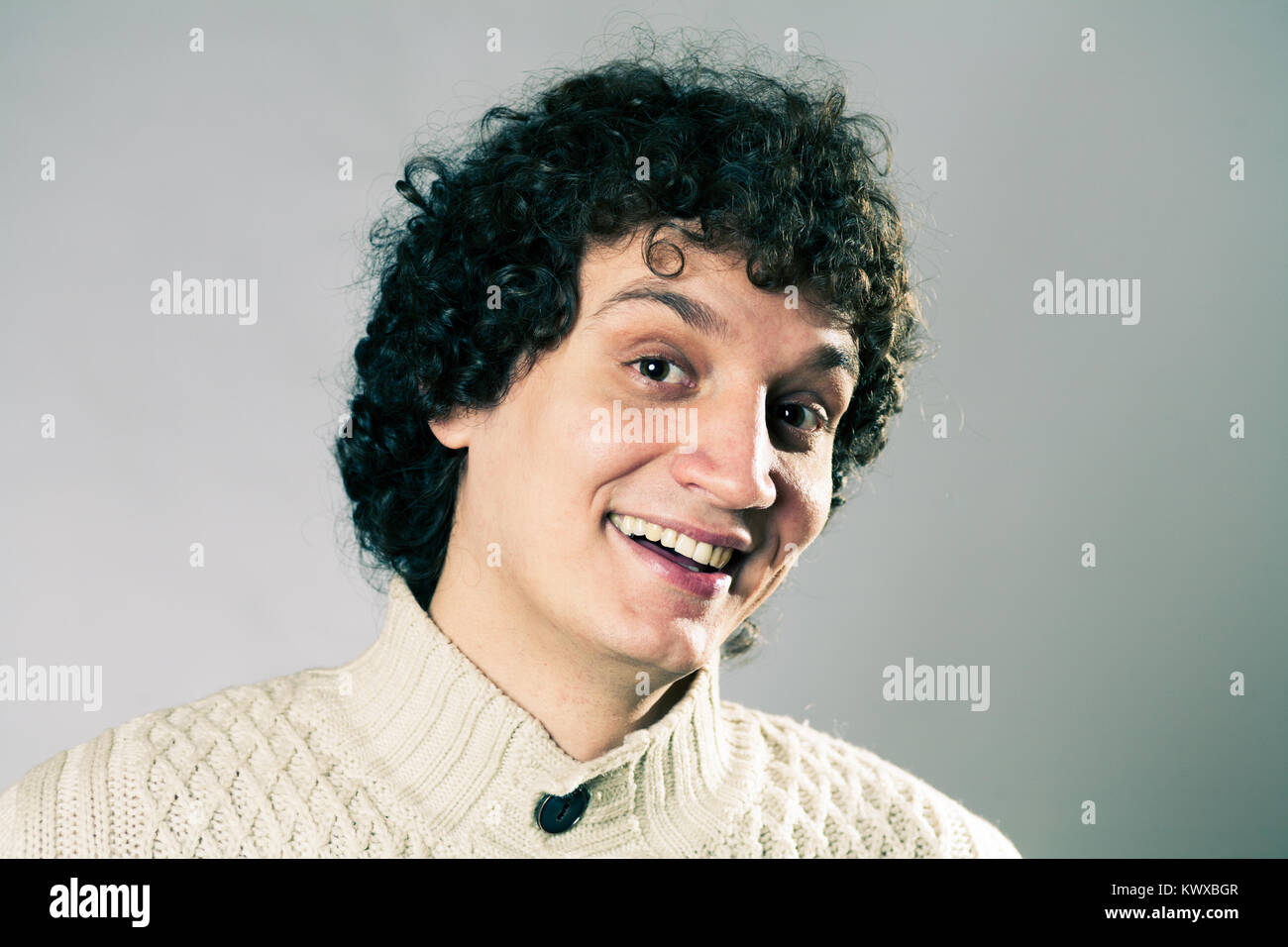 Curly white man in studio smiling Stock Photo - Alamy