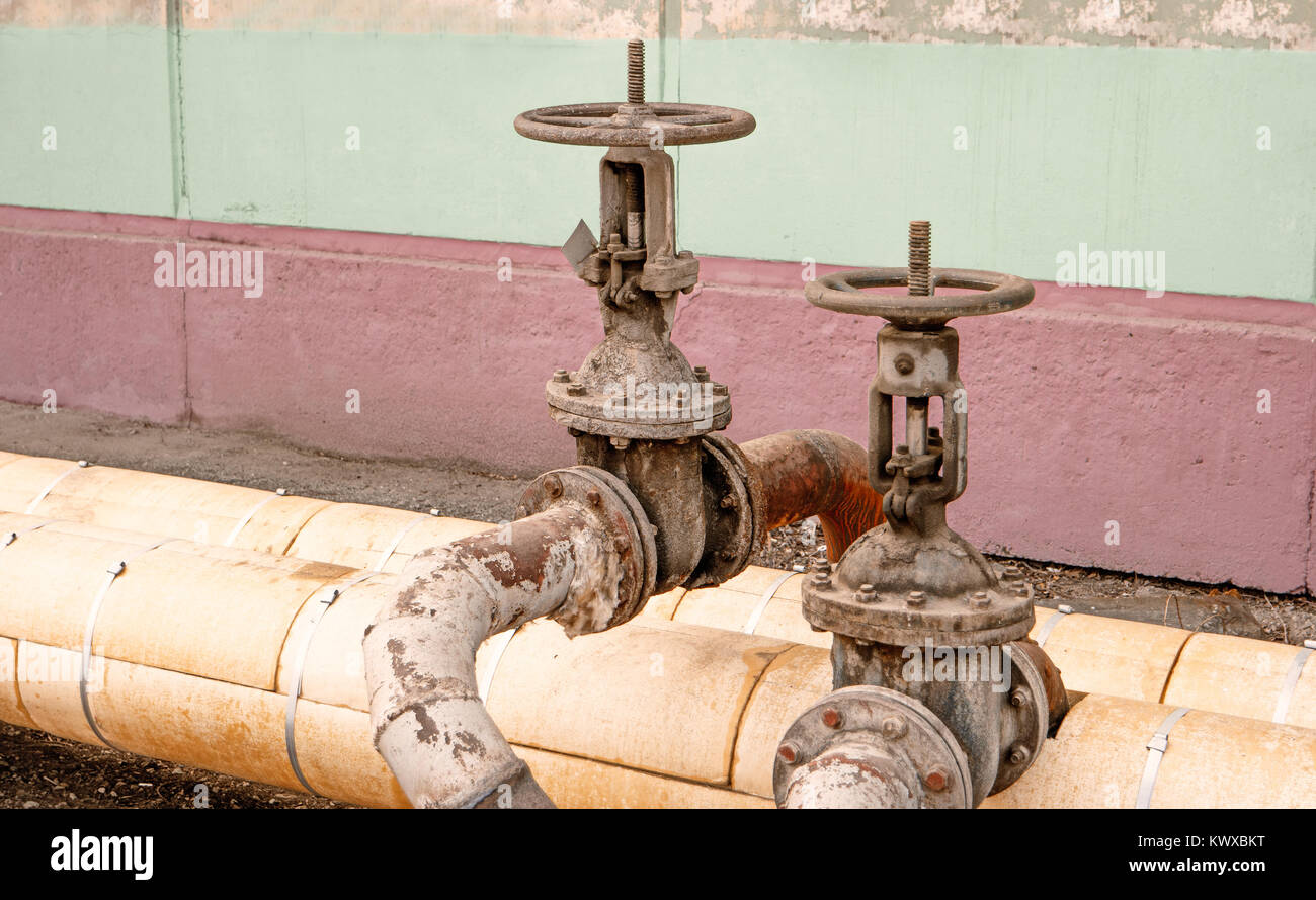 Two old rusty hot water valves onpipes outdoors Stock Photo - Alamy