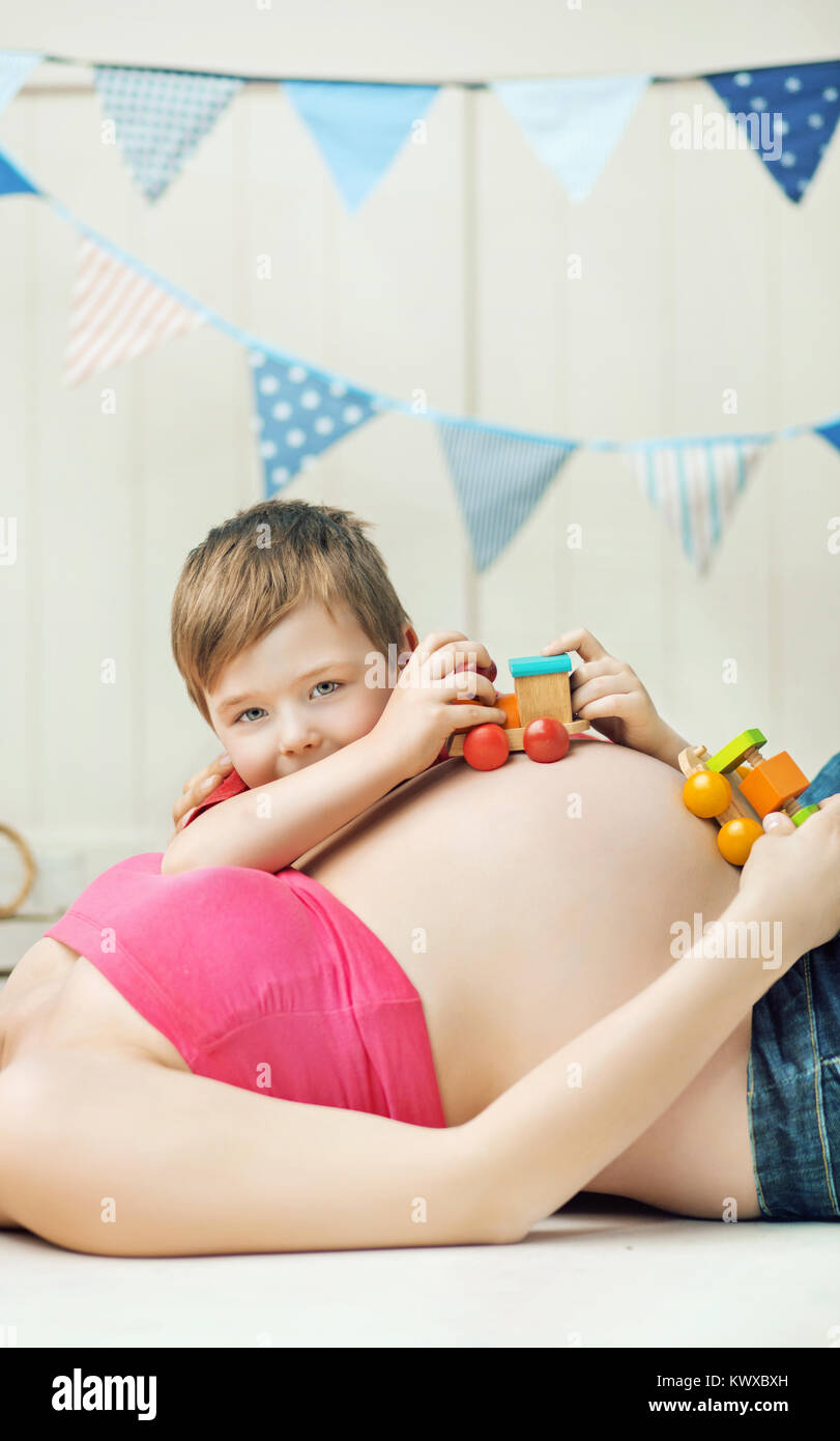 Cute little boy playing with the unborn sibling Stock Photo - Alamy