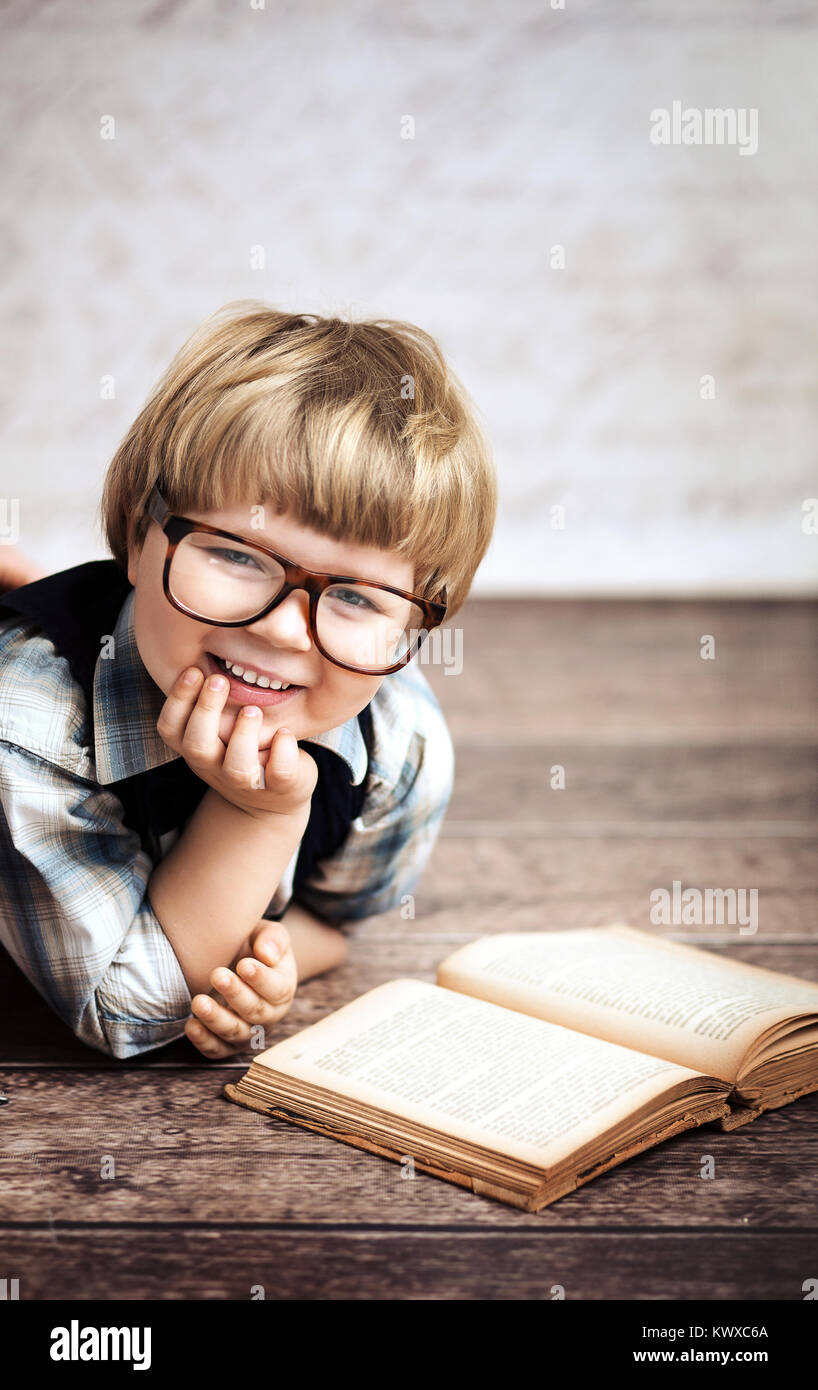 Cheerful smiling little boy reading a book Stock Photo - Alamy