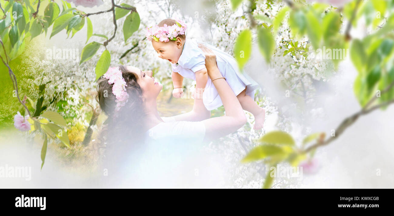 Pretty mother and her little daughter relaxing in a spring orchard ...