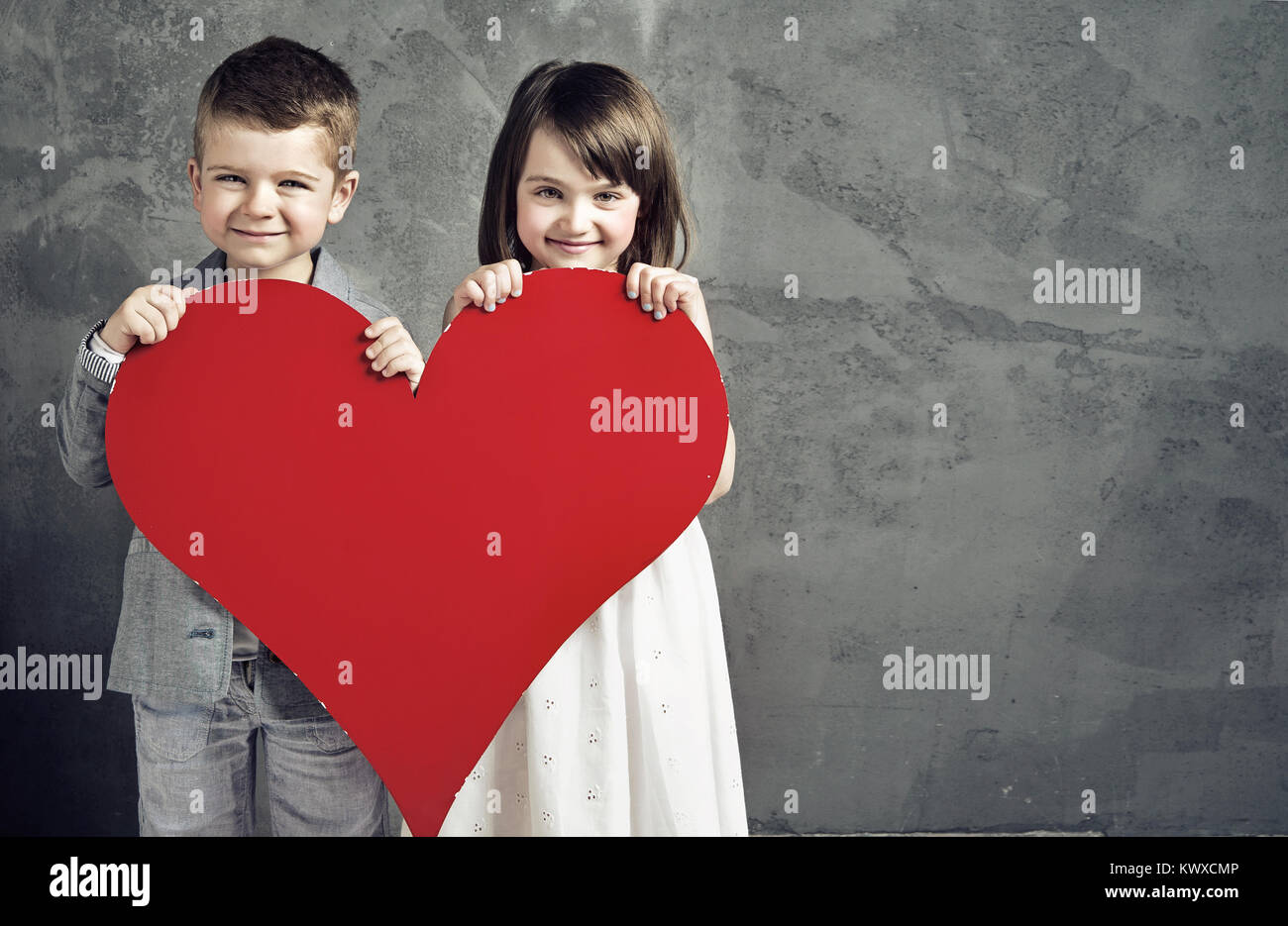 Smiling kids holding a toy heart Stock Photo - Alamy