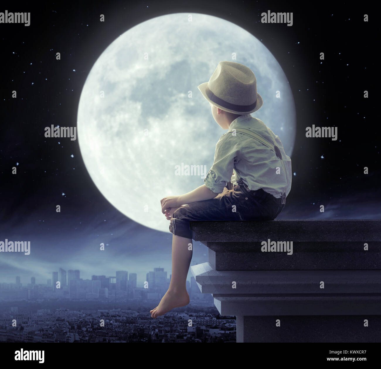 Little man looking a the city in the night Stock Photo - Alamy