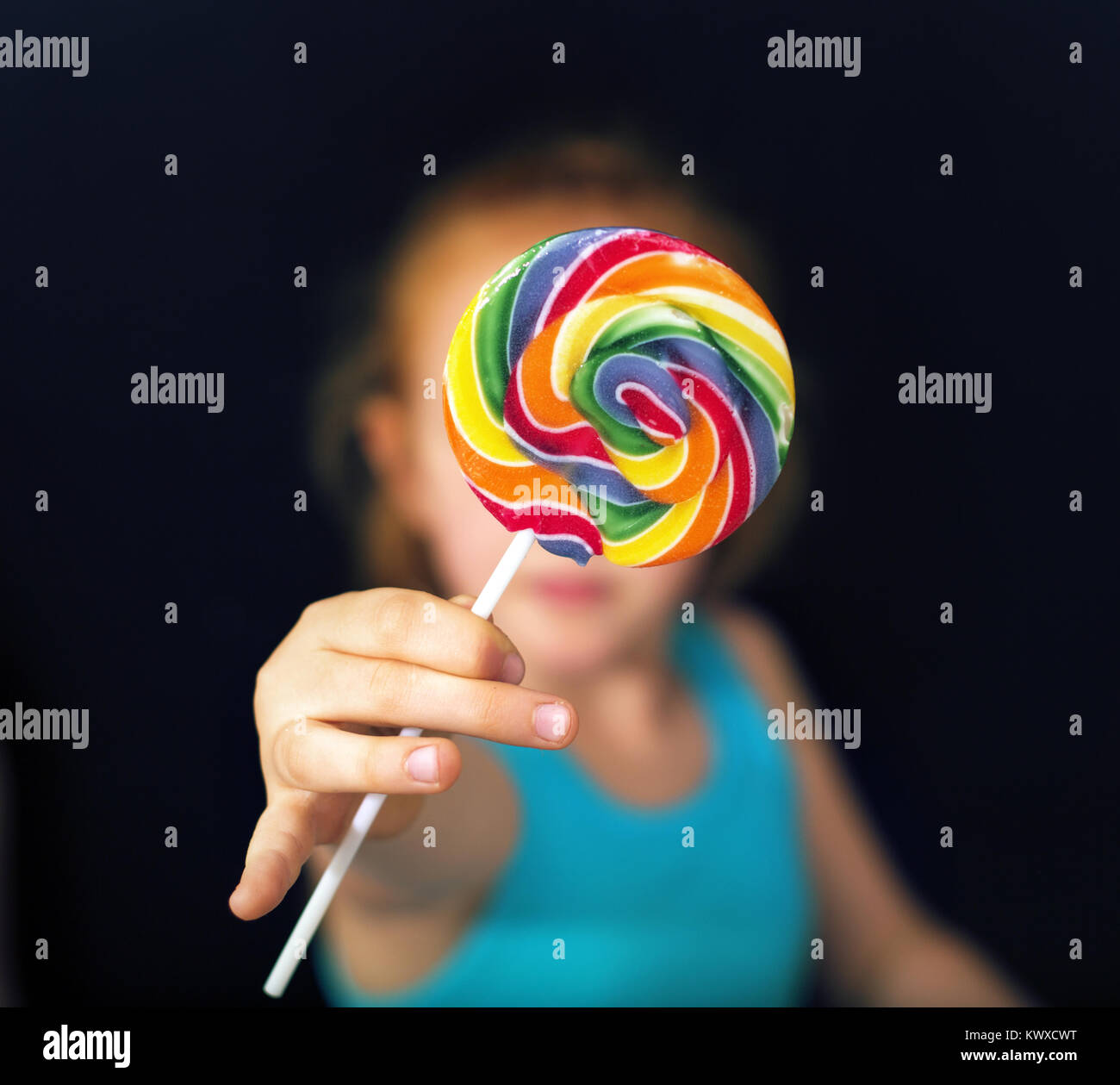 Ginger girl holding a sweet and colorful lollipop Stock Photo - Alamy