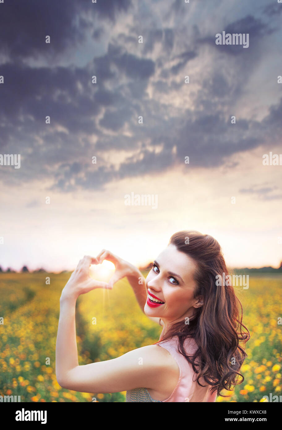 cheerful young lady making a heart sign Stock Photo - Alamy