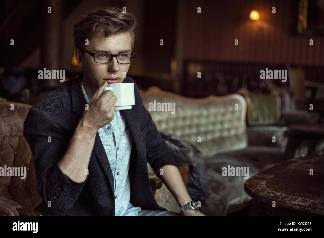 Smart guy drinking an aromatic coffee Stock Photo - Alamy