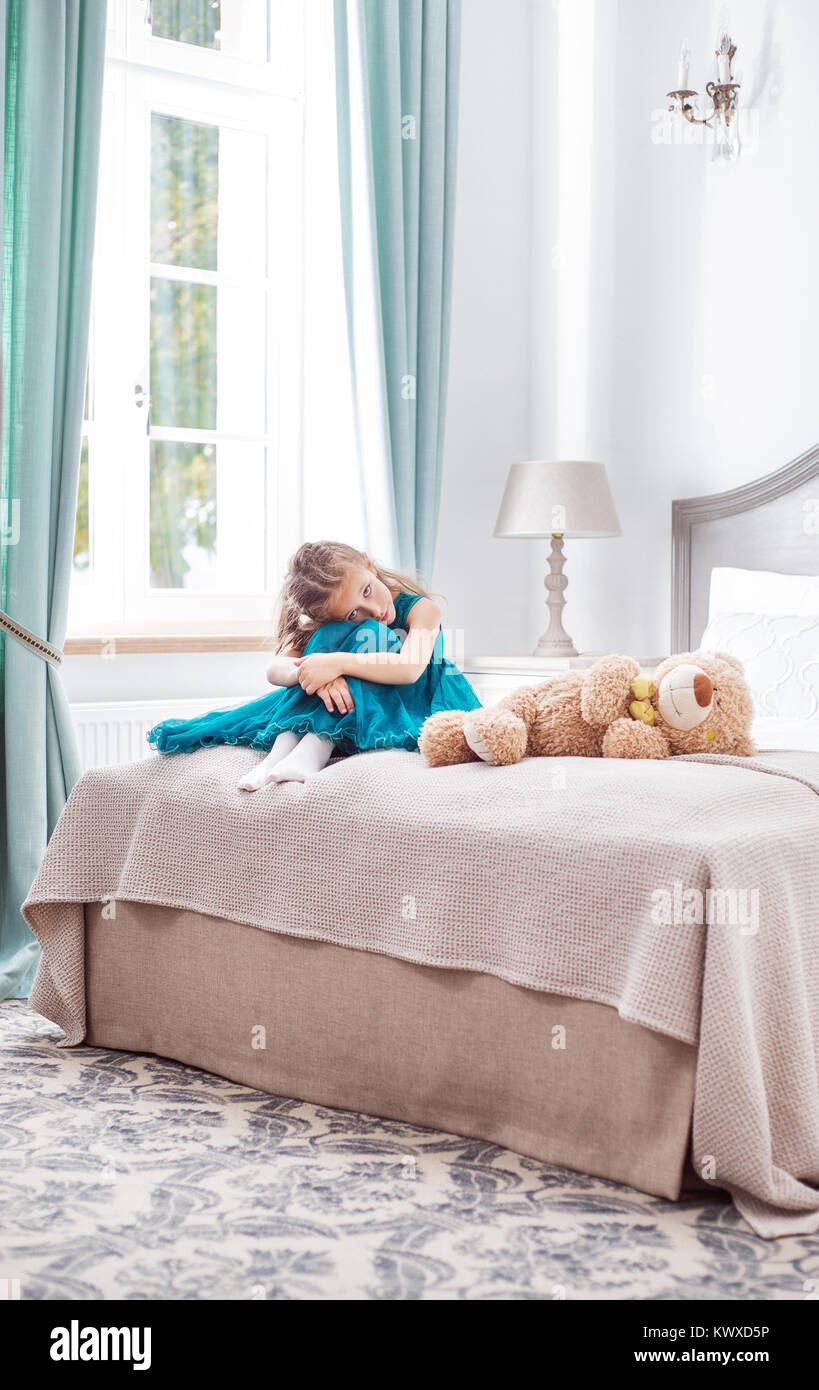 Portrait of the little sad girl alone in the bedroom Stock Photo - Alamy