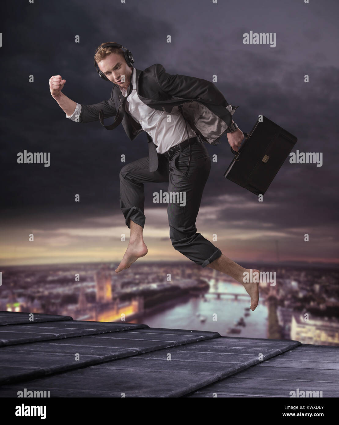 Conceptual photo of a businessman jumping on the top of a skyscraper ...