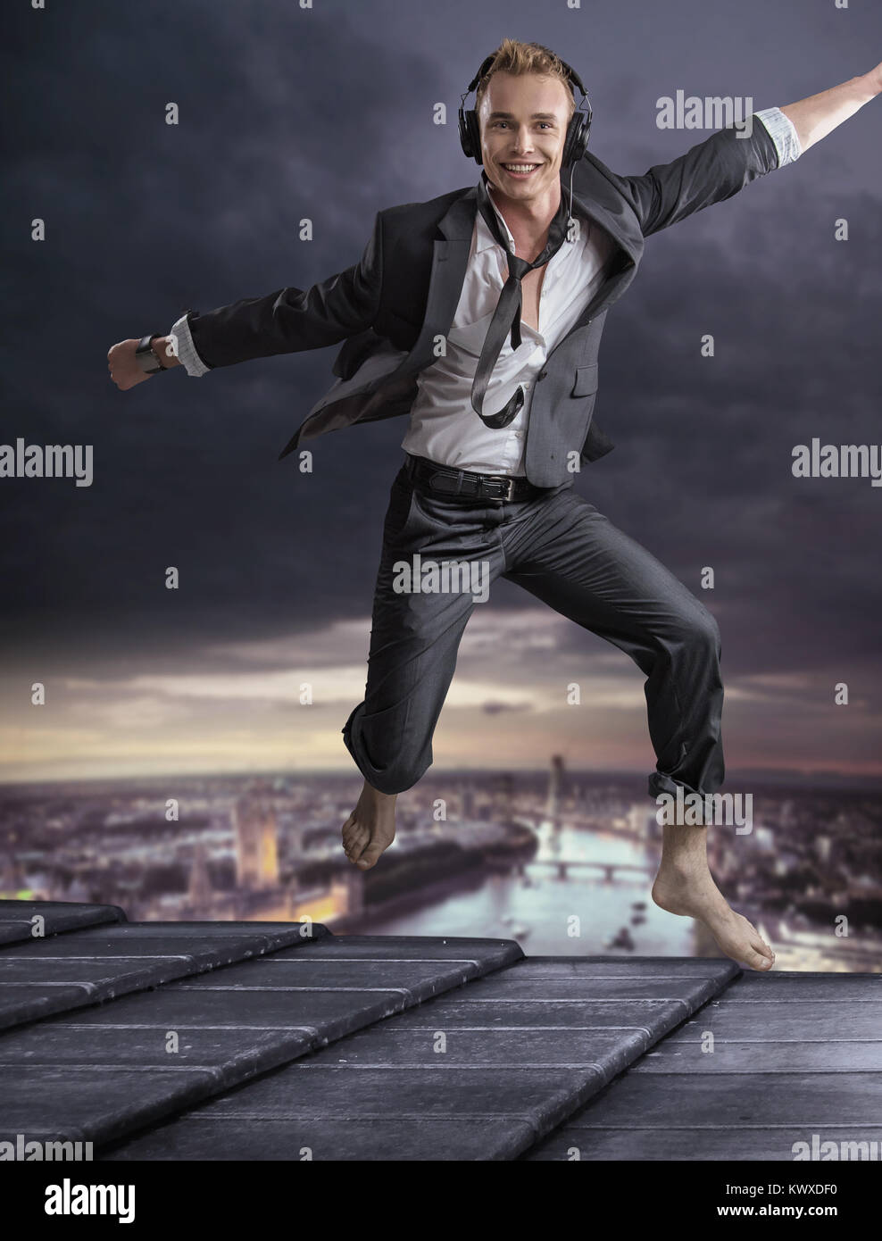 Handsome blond man dancing on the edge of a skyscraper Stock Photo - Alamy