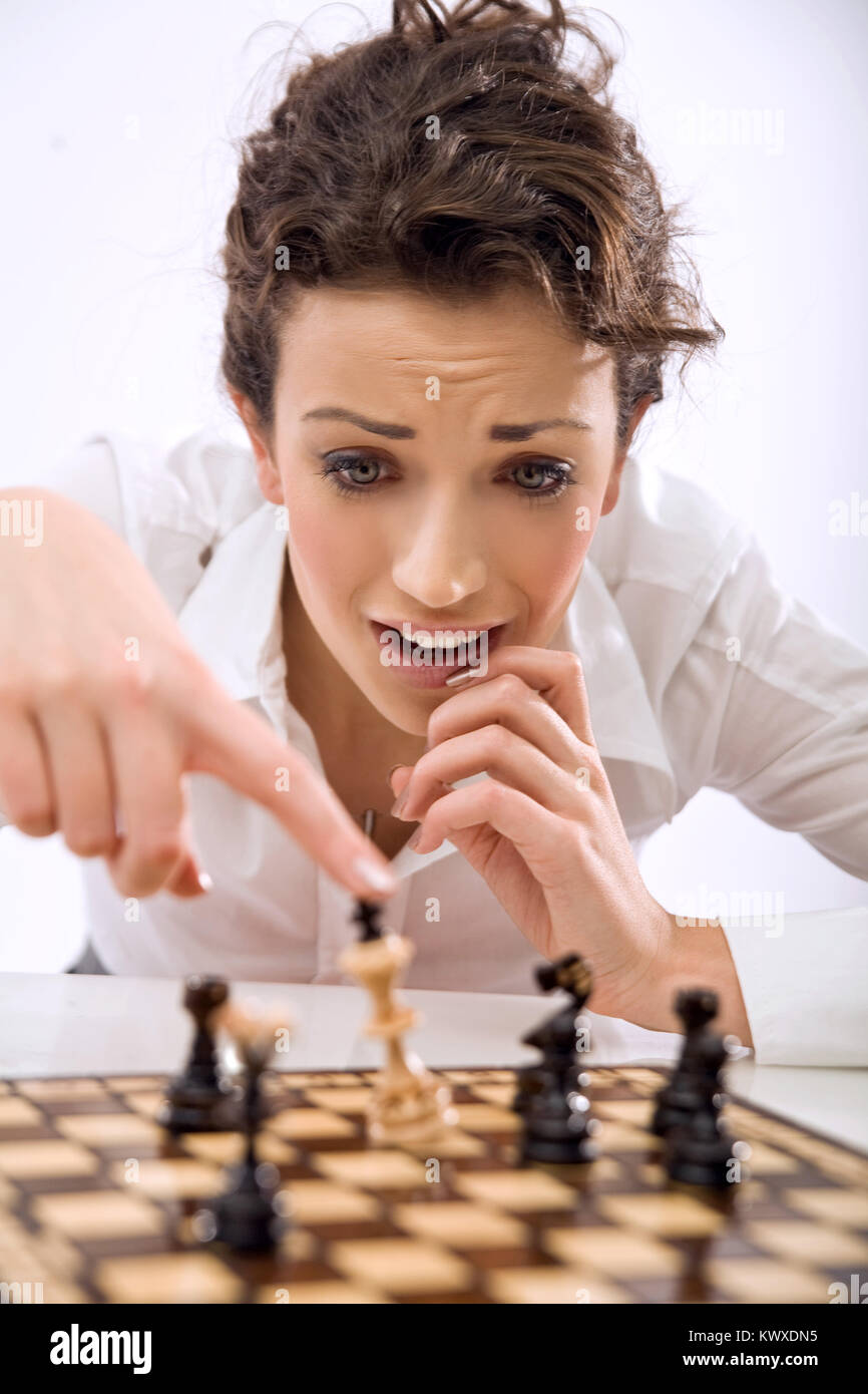 Terried young woman lokking at the chess set Stock Photo - Alamy