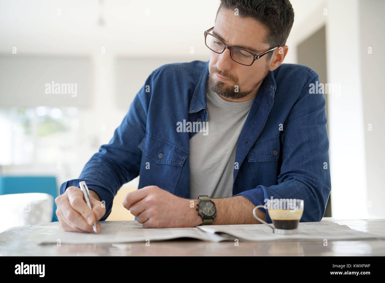 Man at home reading newspaper Stock Photo - Alamy