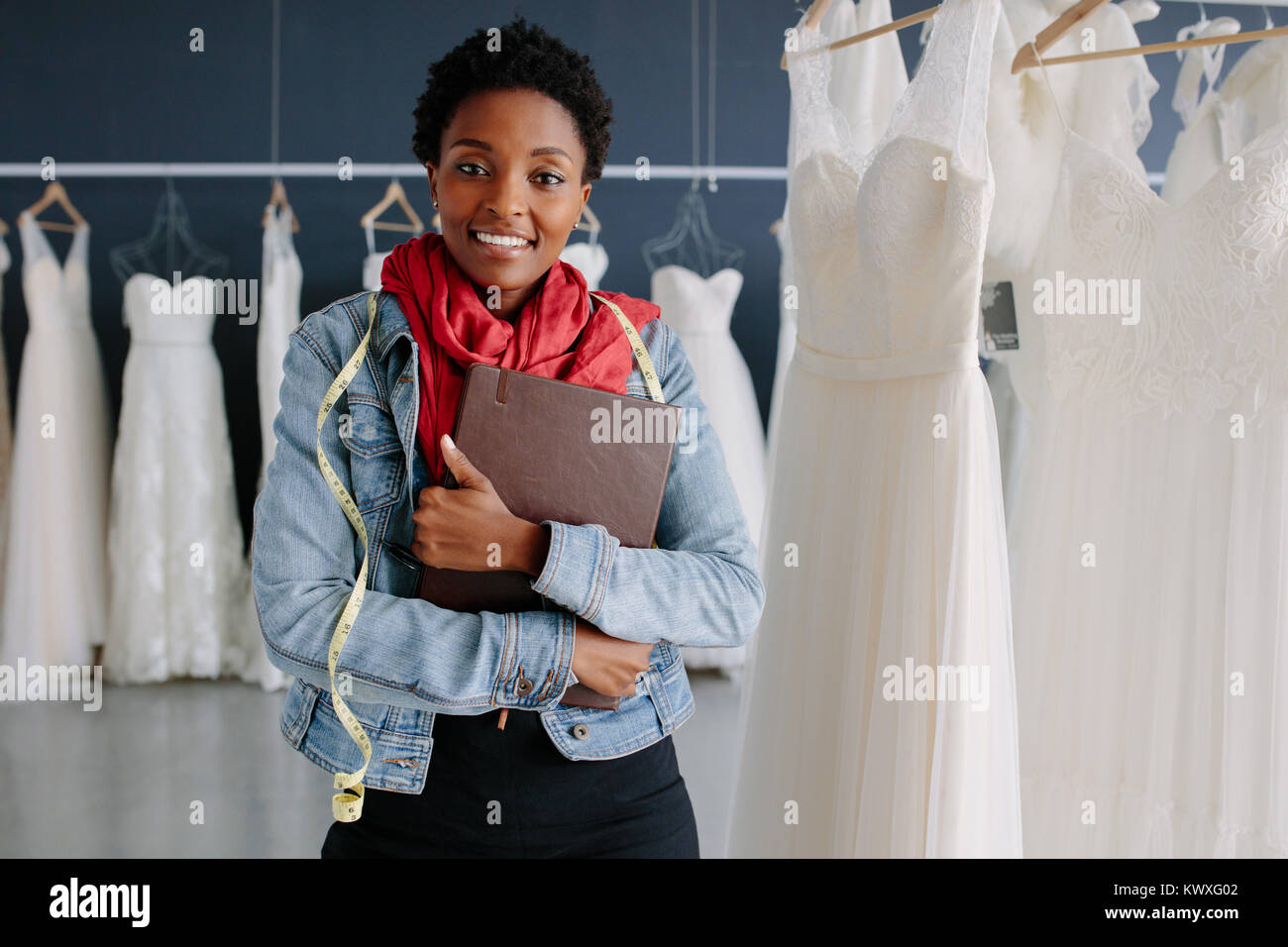 Portrait of wedding dress store owner with a diary. Woman dressmaker in ...
