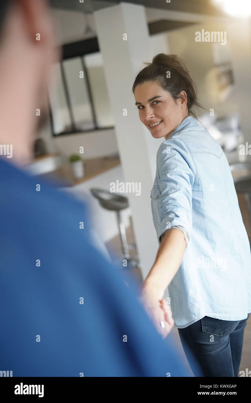 Woman pulling man's arm to follow her inside house Stock Photo - Alamy