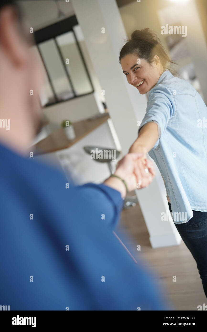 Woman pulling man's arm to follow her inside house Stock Photo - Alamy