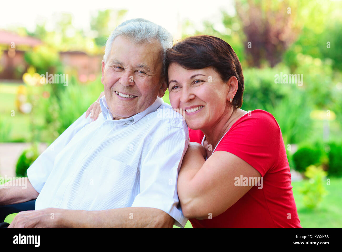 Portrait of happy old father and his 50 years daughter at homegarden ...