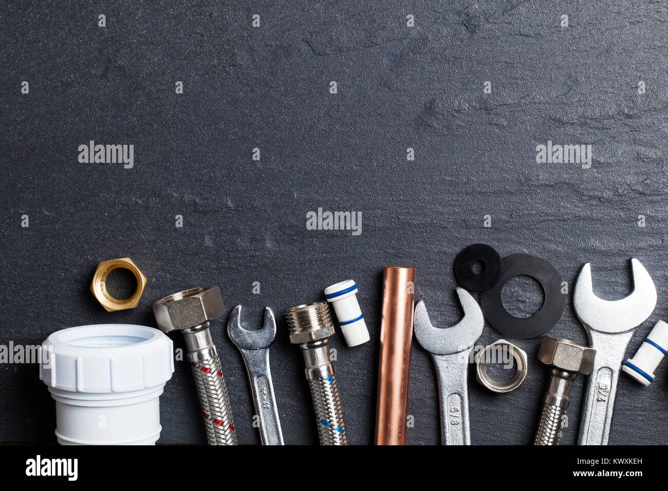 Plumbing concept. tools and pipes on a dark slate bakground Stock Photo ...