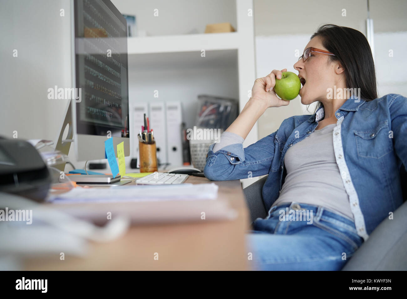 Office worker taking a break in front of desktop Stock Photo - Alamy