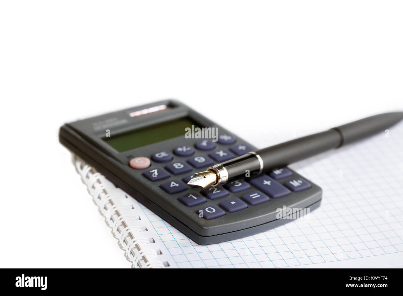 Fountain pen lying on calculator and spiral notebook isolated on white ...