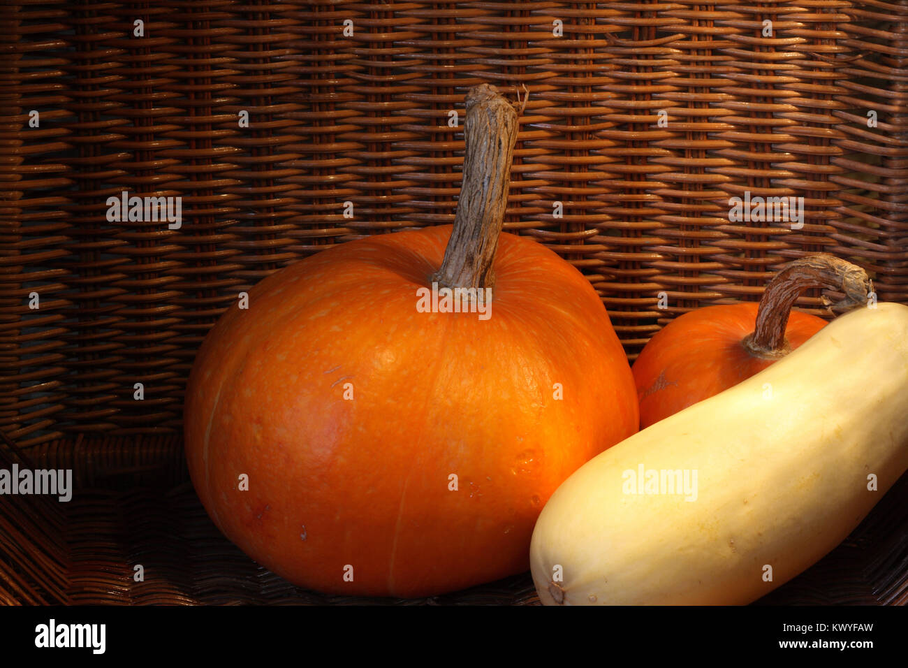 Two pumpkins and marrow squash inside wicker basket Stock Photo - Alamy