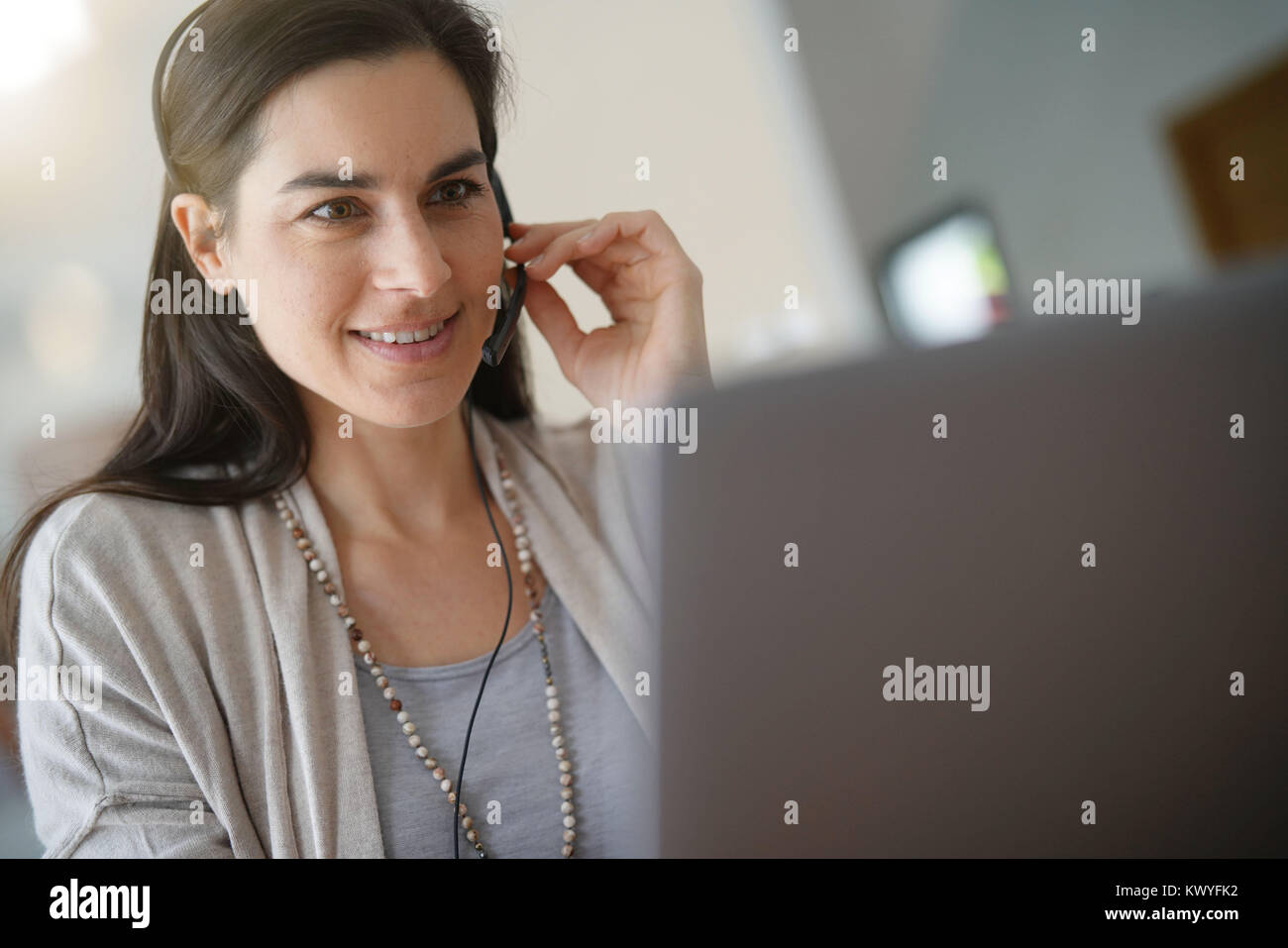 Home-office teleoperator talking on phone with headset Stock Photo - Alamy