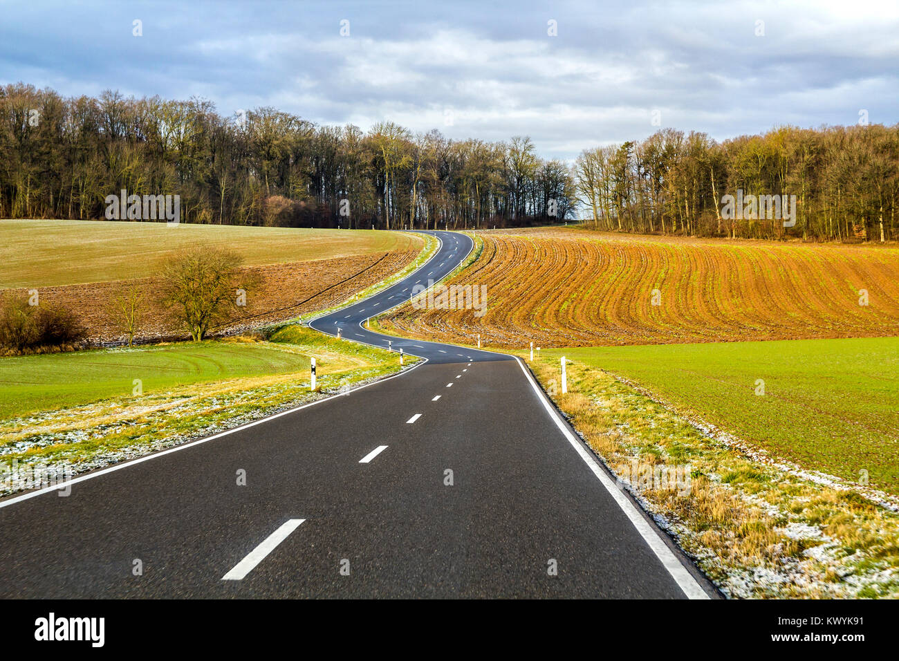 Empty black asphalt road between green fields Stock Photo - Alamy