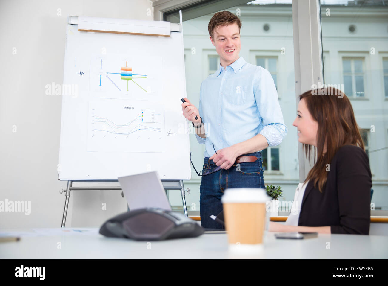 Smiling Businessman Giving Presentation To Colleague In Office Stock ...