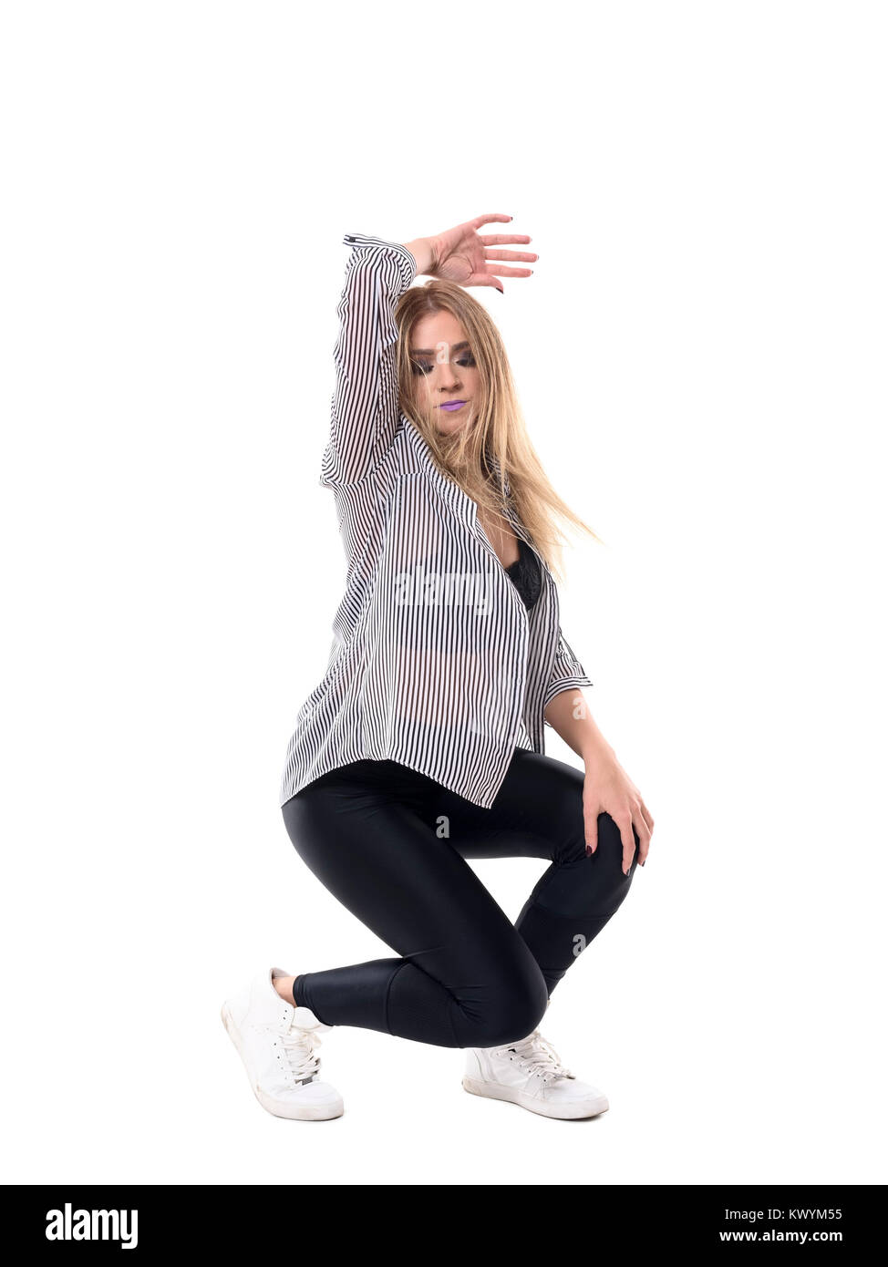 Attractive blonde jazz dancer woman crouching pose with hand resting on ...