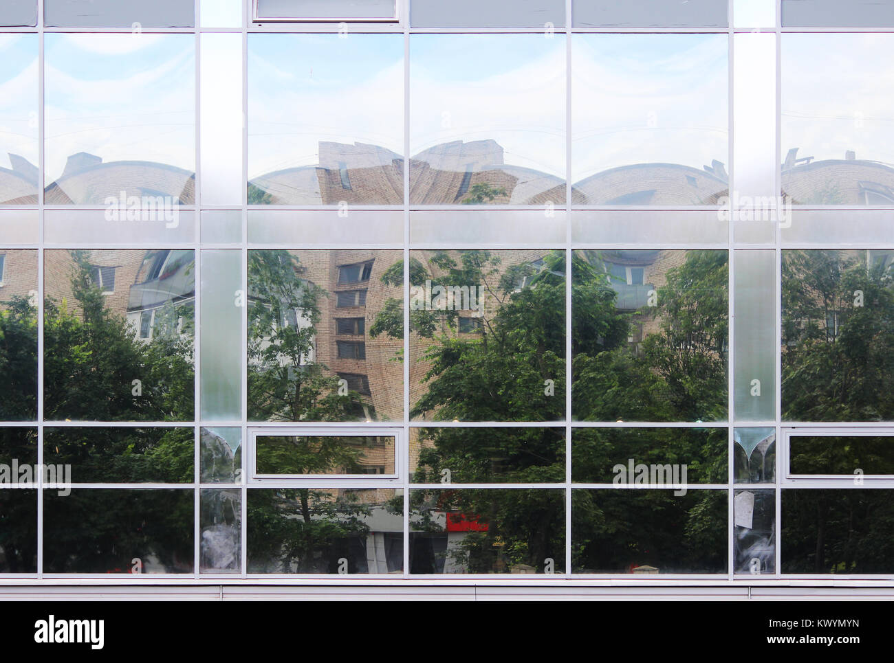 city houses are deformed distorted reflected in the windows of a large ...