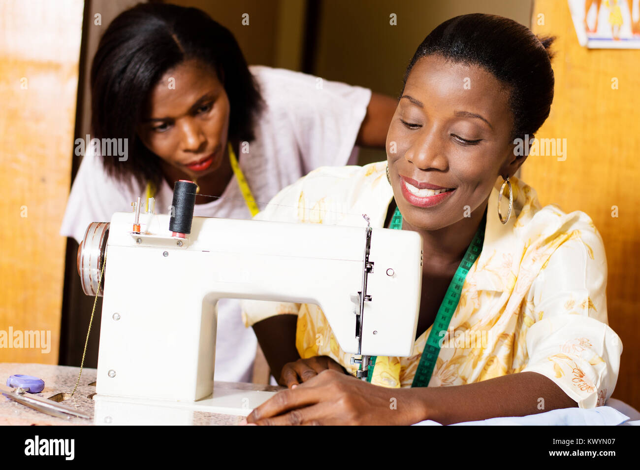 professional dressmaker is pleased to learn sewing to her student Stock ...