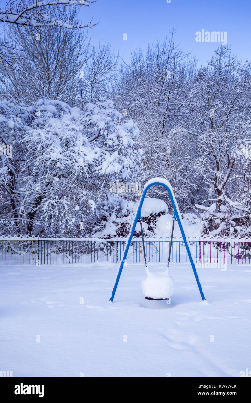 Playground blue swing in snow on white tree branches background Stock ...