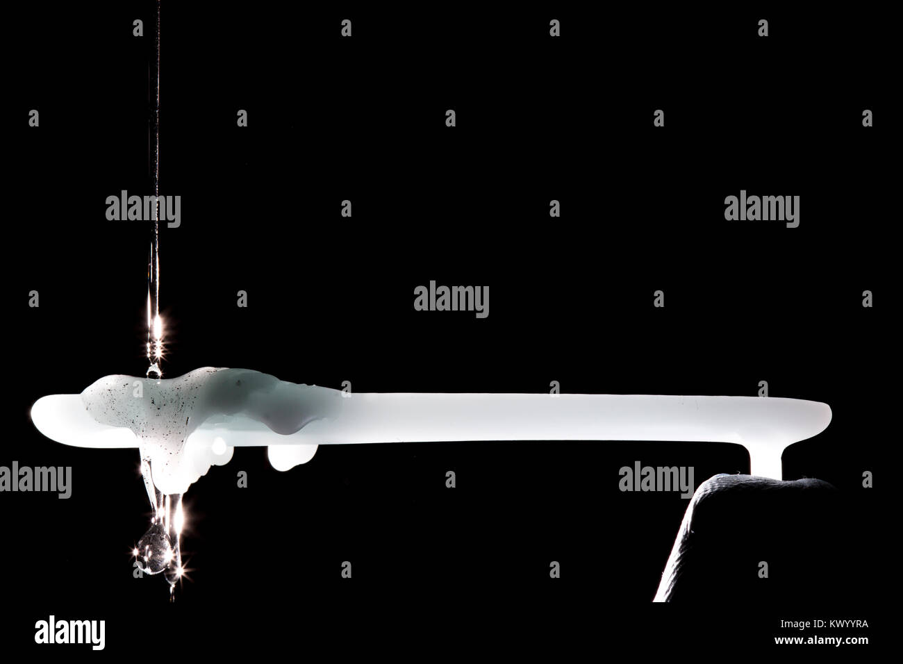 Dripping wax on a wax stick on a plain black background Stock Photo - Alamy