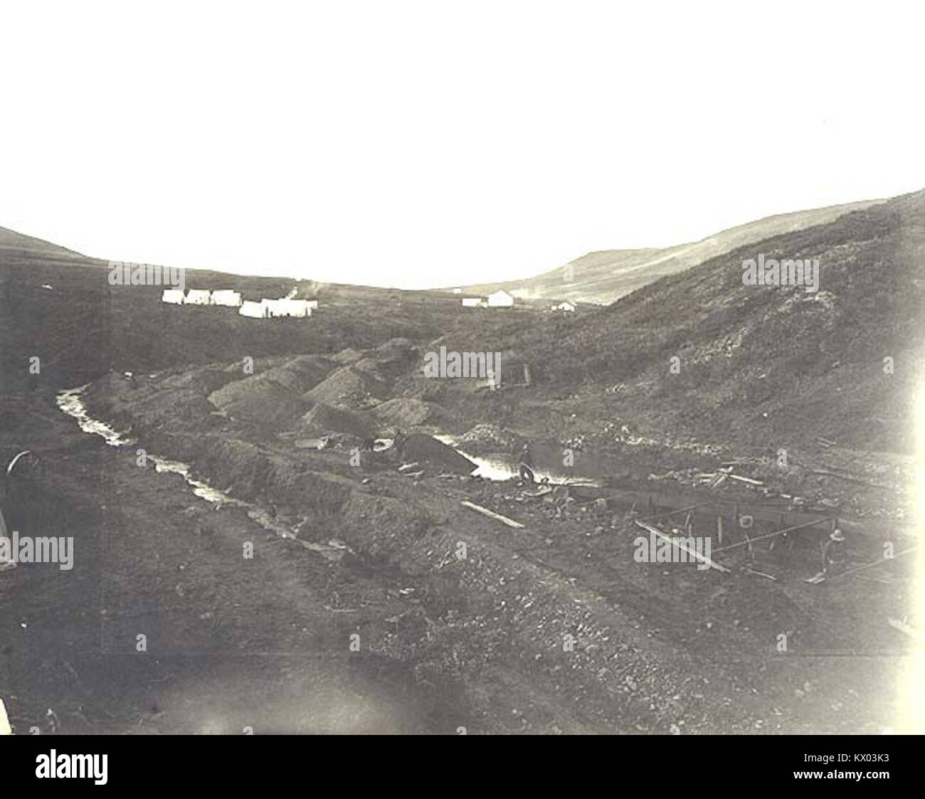 This photograph depicts a mining operation using sluices in Nome ...