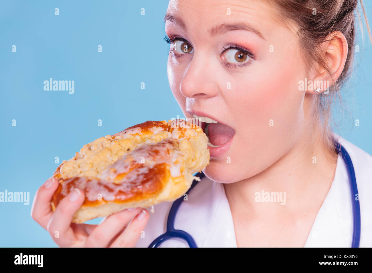 Dietitian nutritionist eating sweet roll bun. Woman with fattening junk ...