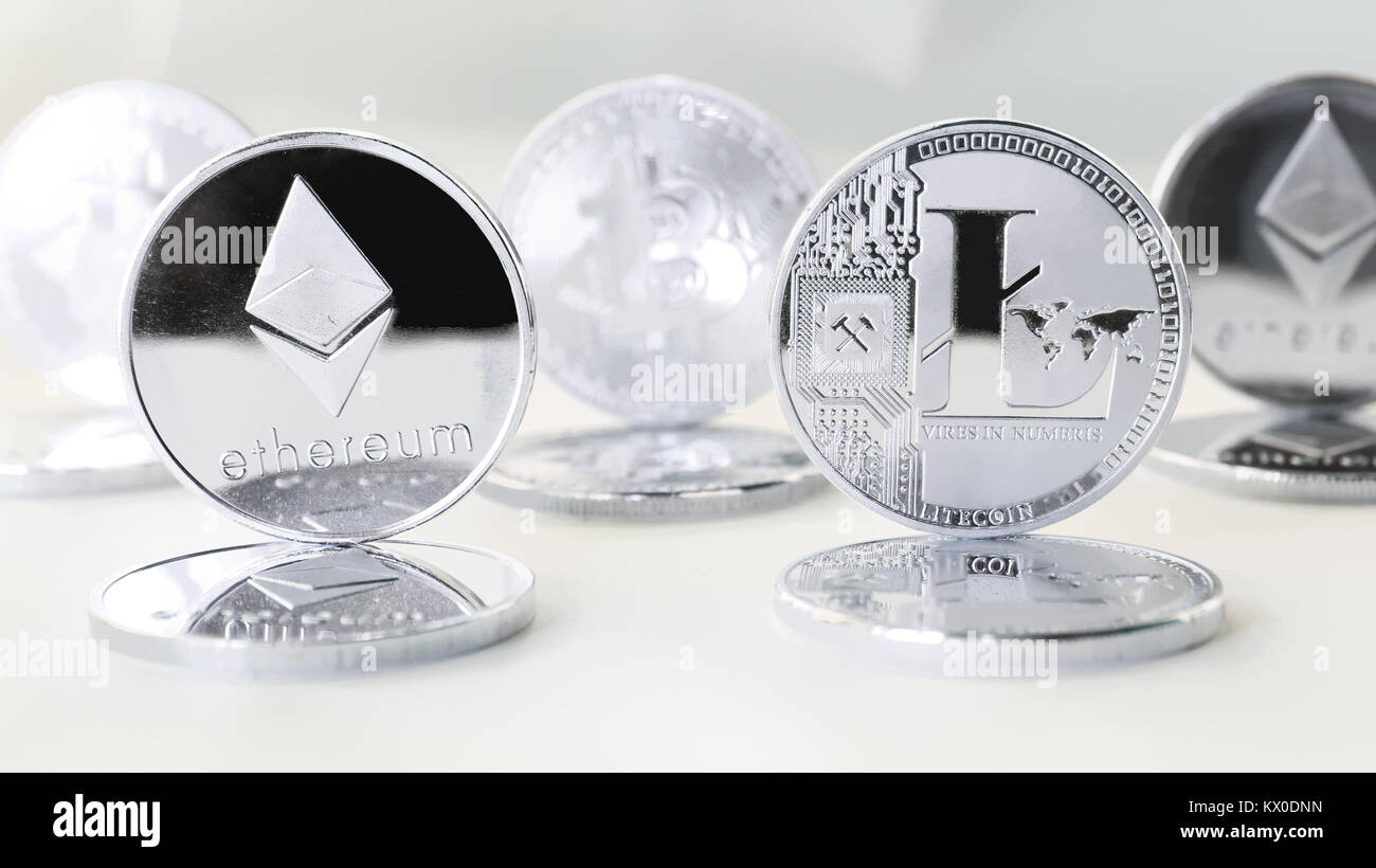 On a white background are silver coins of a digital crypto currencies ...