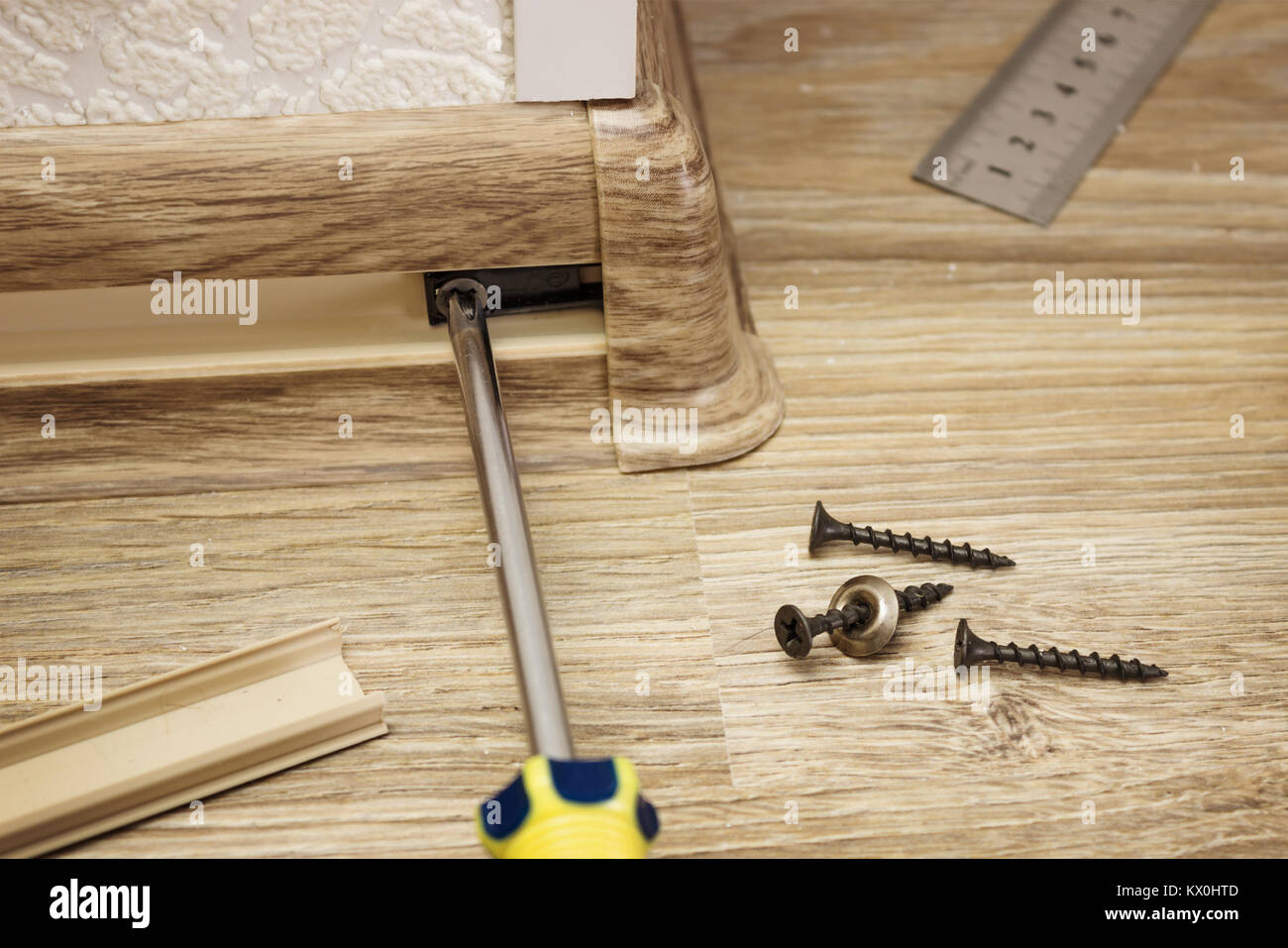 Installing skirting boards in the corner of the room Stock Photo - Alamy