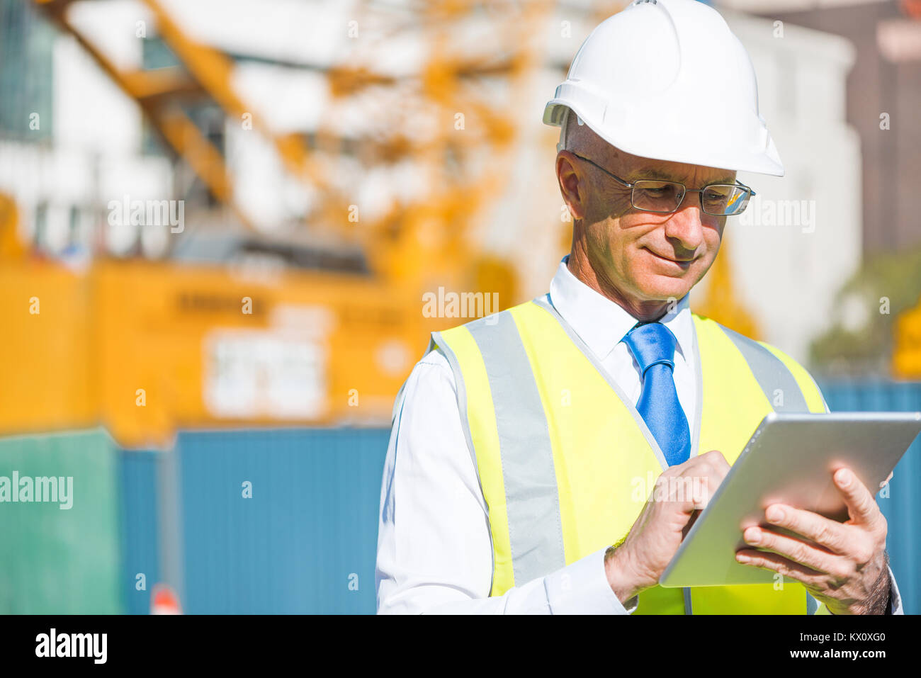 Senior engineer man in suit and helmet working on tablet pc Stock Photo ...